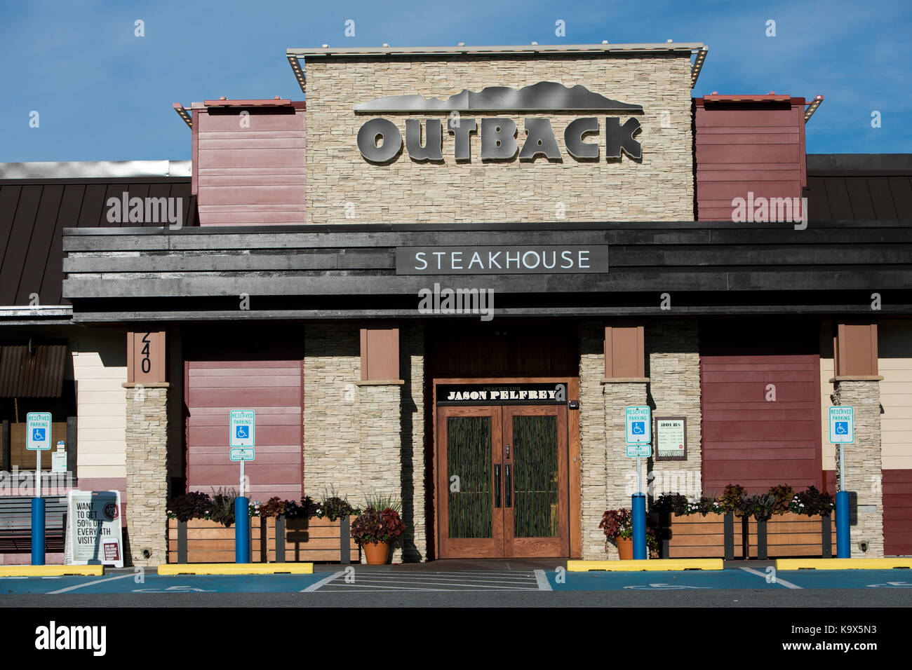 A logo sign outside of a Outback Steakhouse restaurant location in ...