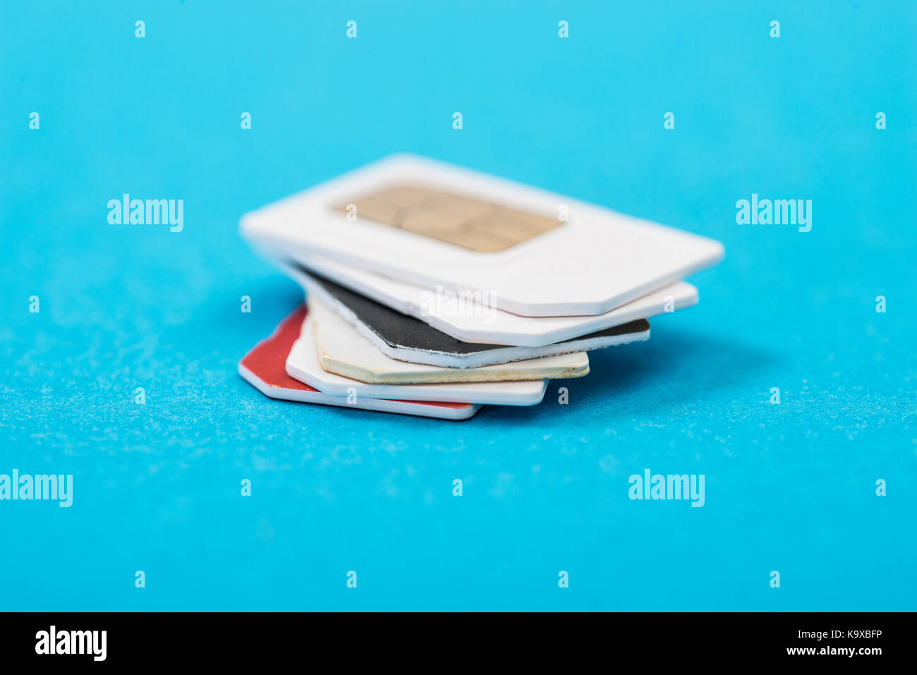 Stack Of Phone Sim Card Over Blue Background Stock Photo - Alamy