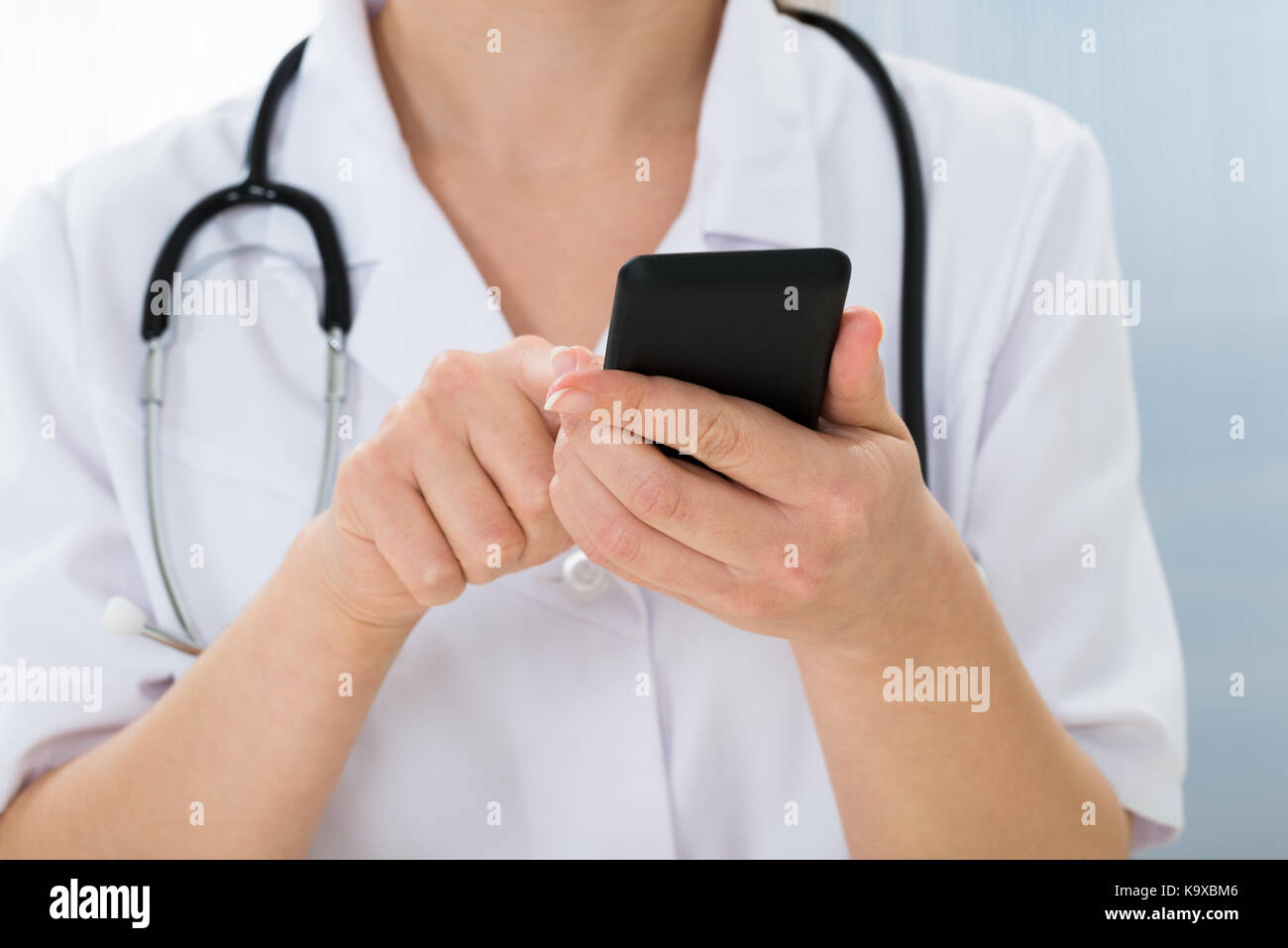 Close-up Of Doctor With Stethoscope Using Mobile Phone Stock Photo - Alamy