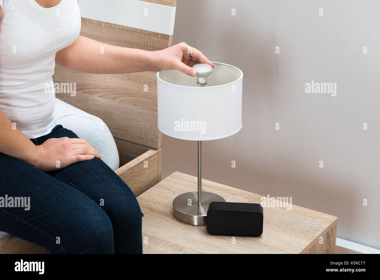 Close-up Of Woman Fixing Lamp On Nightstand Stock Photo - Alamy