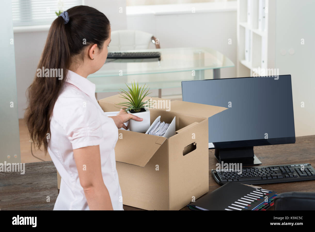 Young Businesswoman Packing Belongings In Cardboard Box At Desk Stock ...