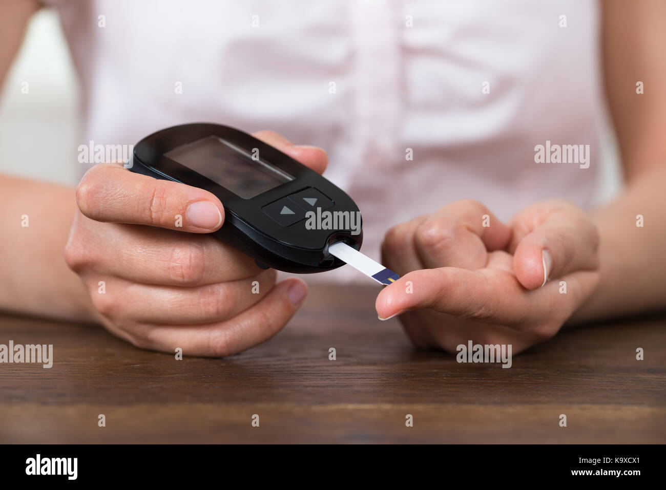 Close-up Of Person Hands Holding Glucometer At Desk Stock Photo - Alamy