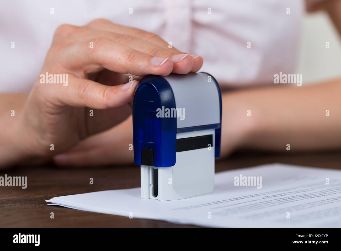 Close-up Of Person Hands Stamping Document At Desk Stock Photo - Alamy