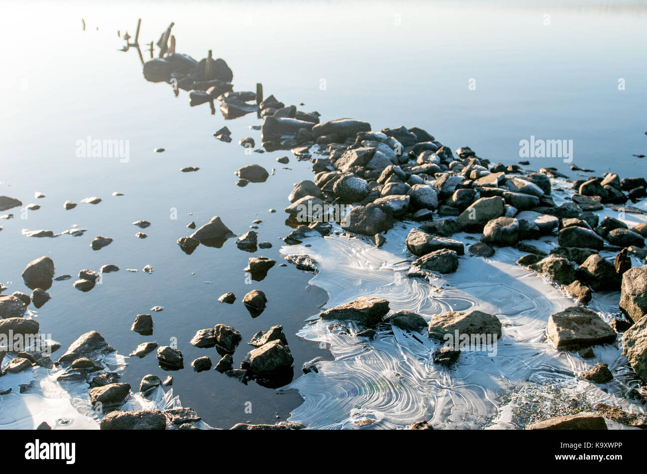 Stone fence disappearing into a icy lake Stock Photo - Alamy