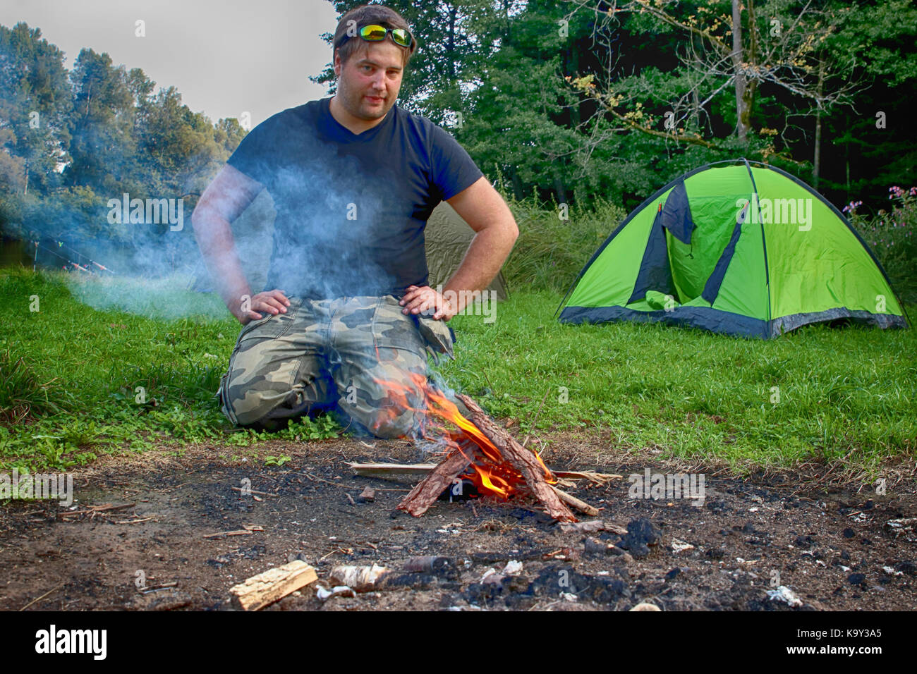 Young man with tent while fishing Stock Photo - Alamy
