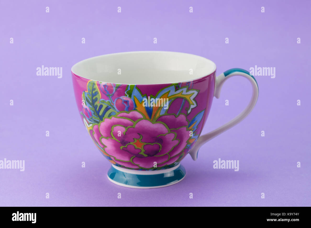 Beautiful stylized empty rose tea cup isolated on lilac background ...