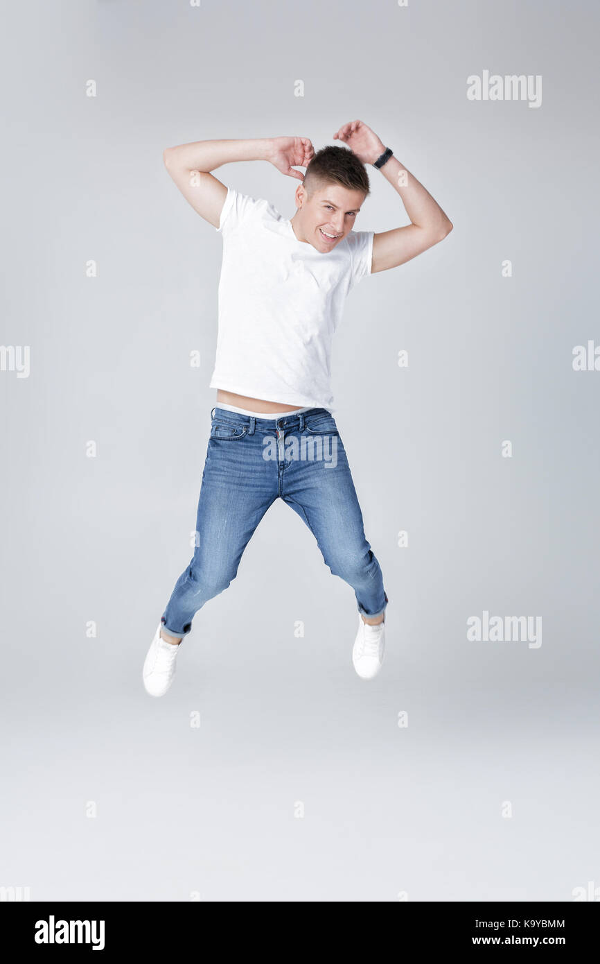 handsome man in jeans and jacket jumping Stock Photo - Alamy