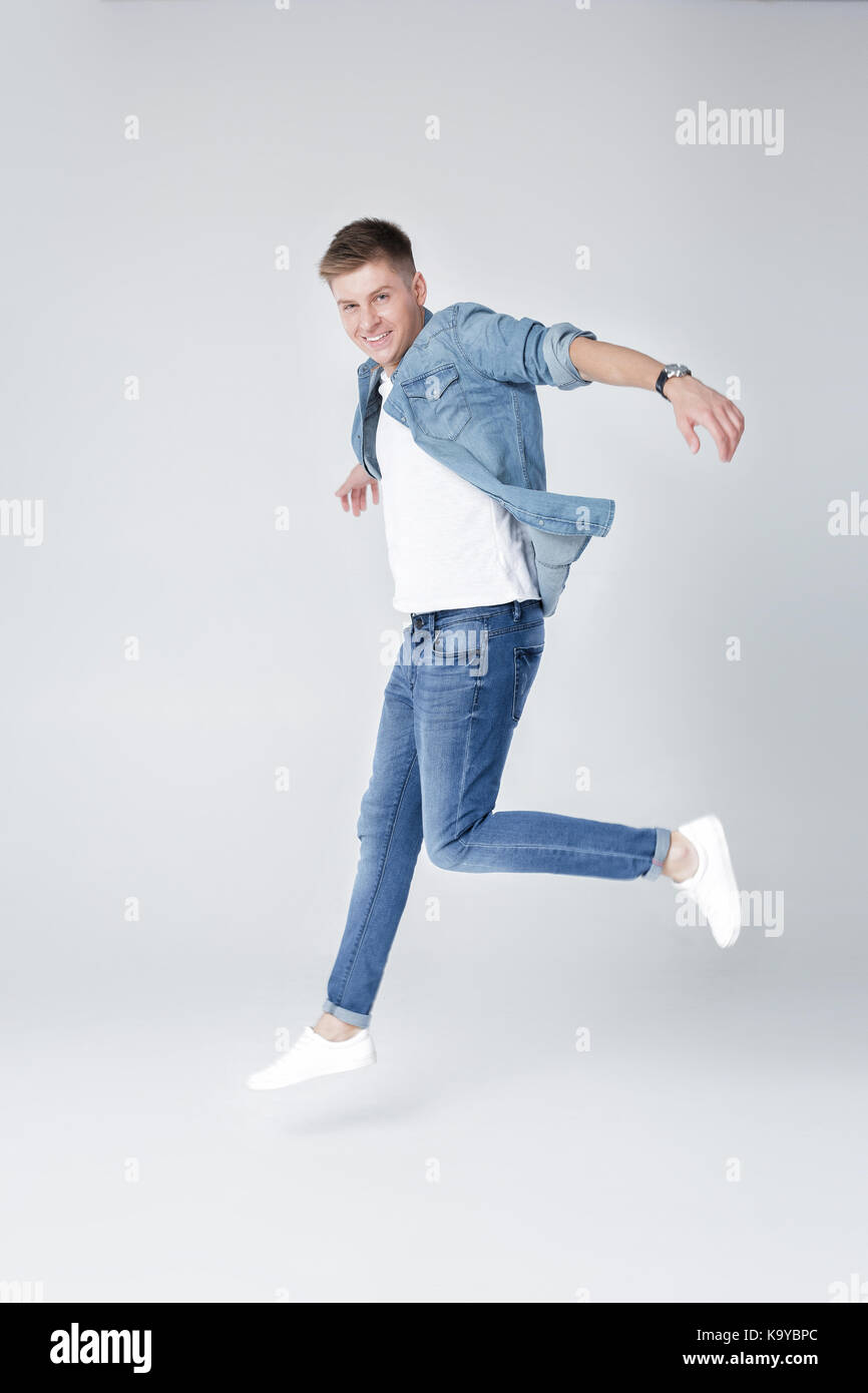 handsome man in jeans and jacket jumping Stock Photo - Alamy