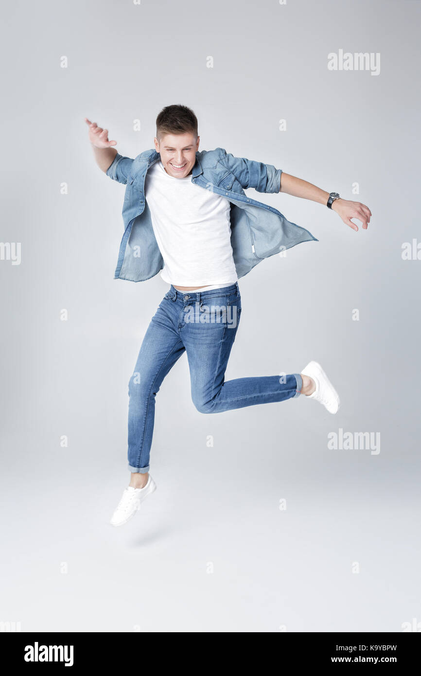 handsome man in jeans and jacket jumping Stock Photo - Alamy
