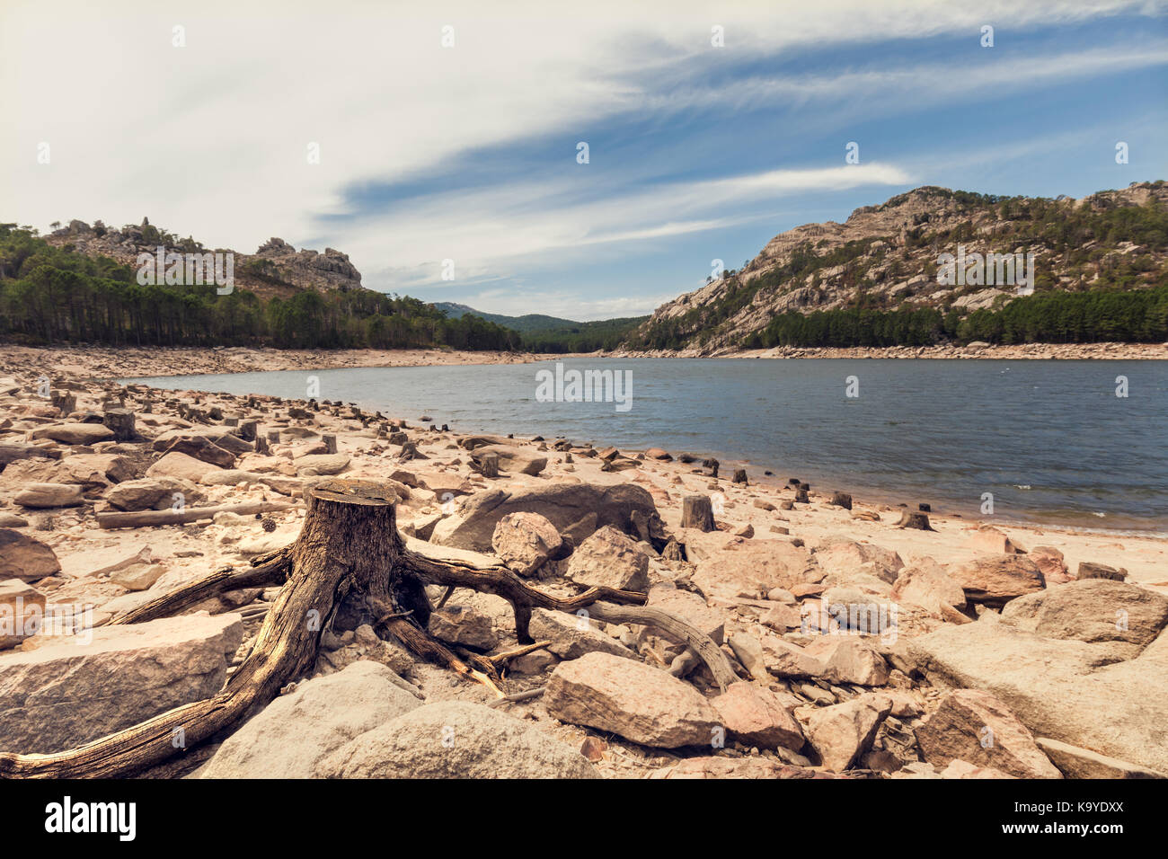 Old tree stump amongst the rocks and boulders on the banks of Lac de l ...