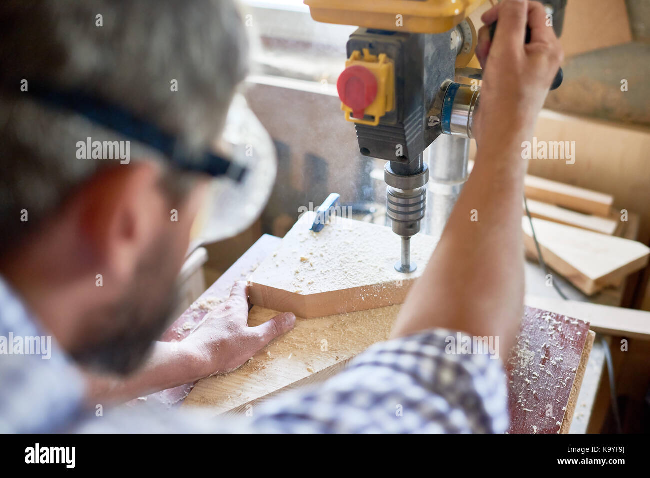 Back view portrait of carpenter making wooden furniture in workshop ...