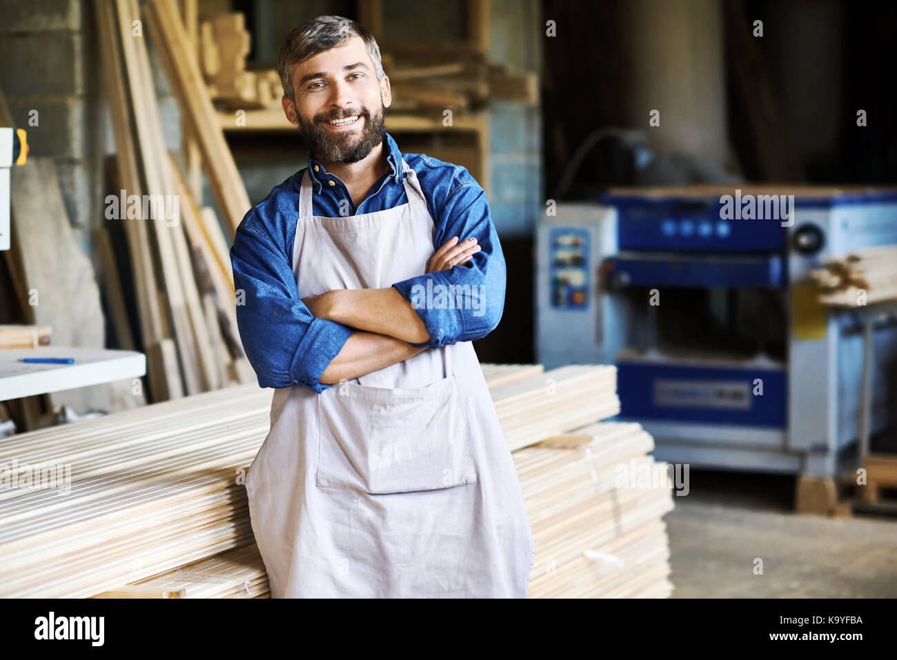 Portrait of mature bearded carpenter posing confidently with arms ...