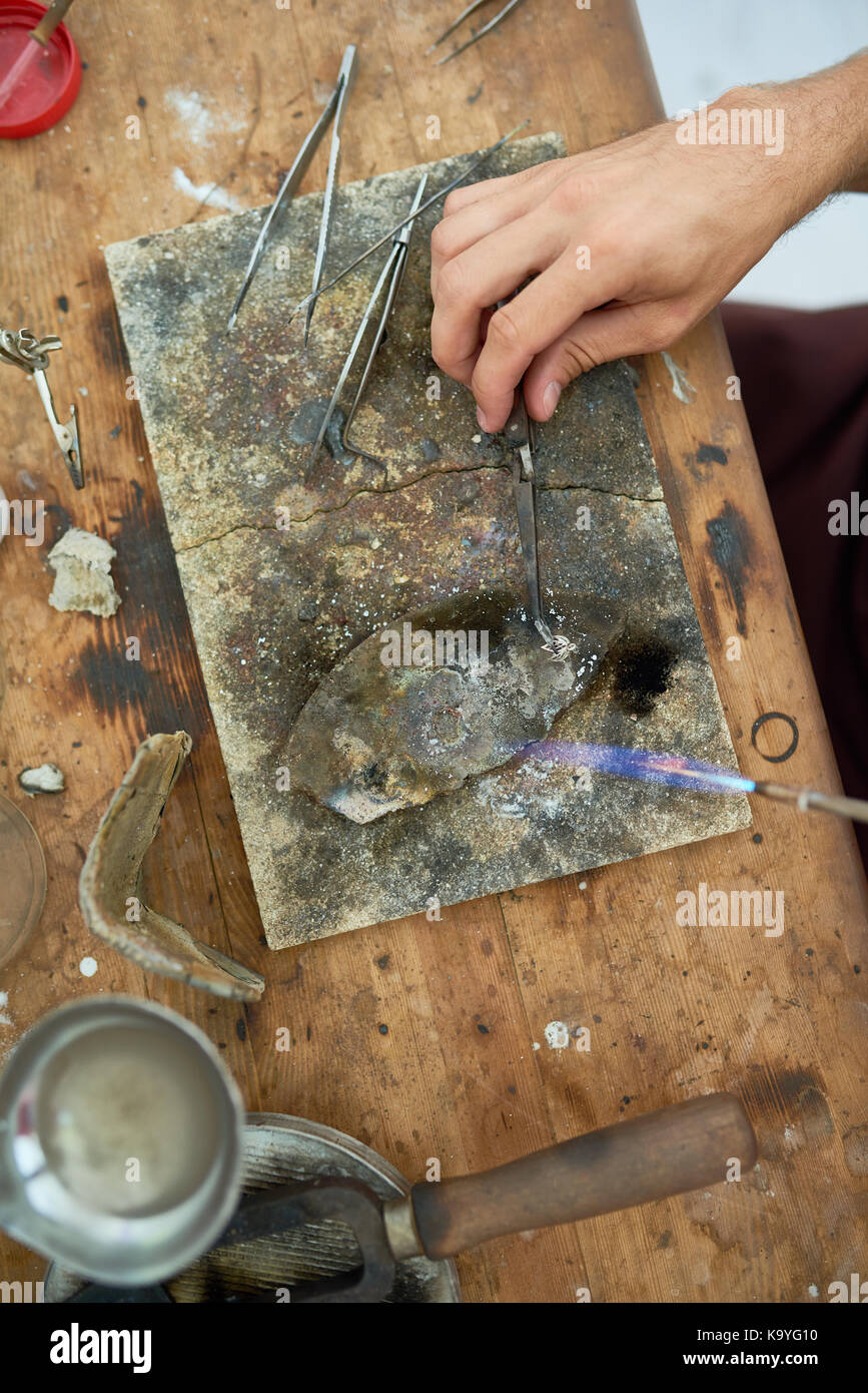 Top view closeup of male hands holding small gas torch and welding ...
