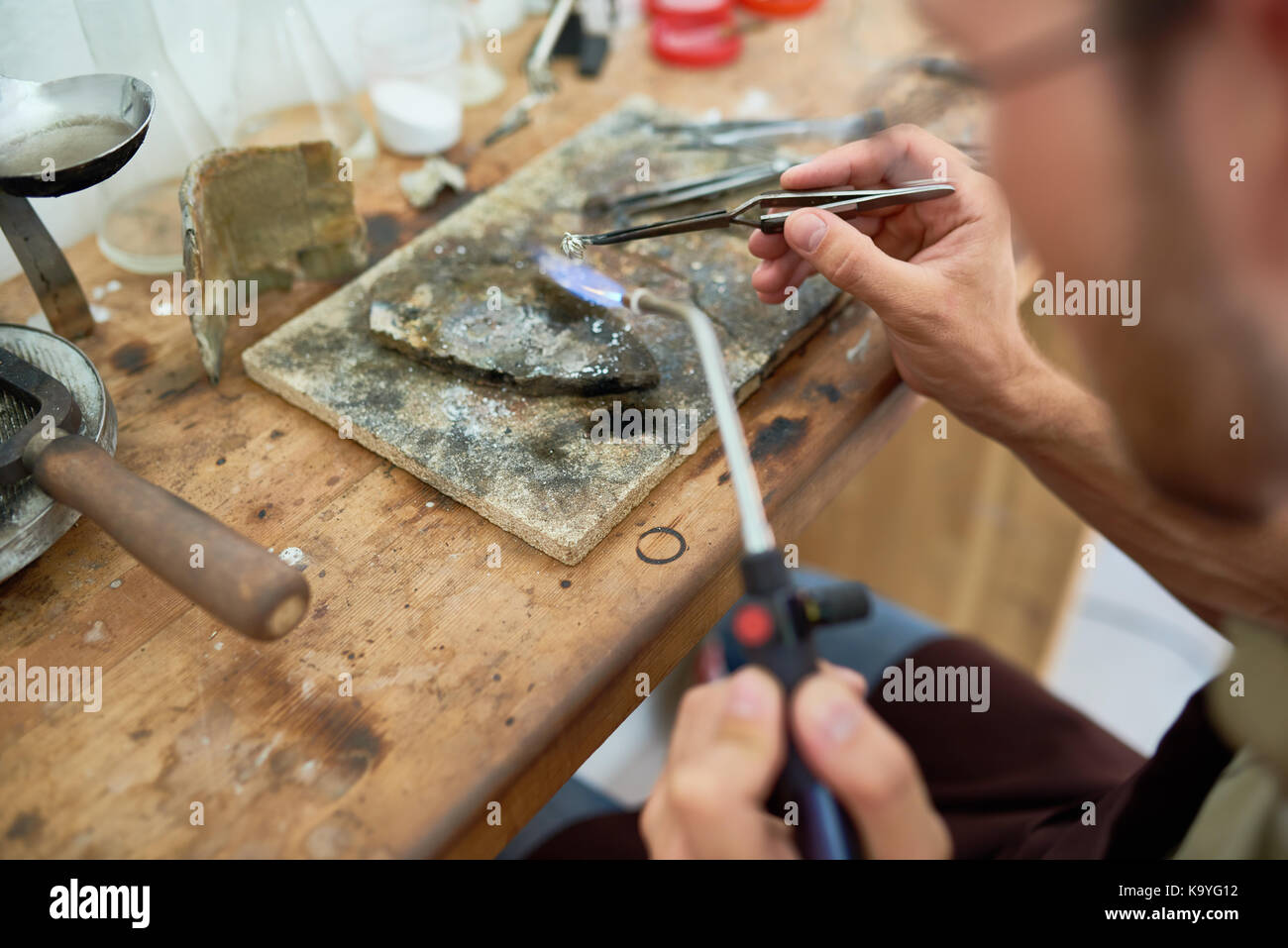 Closeup of male hands holding small gas torch and welding tools while ...