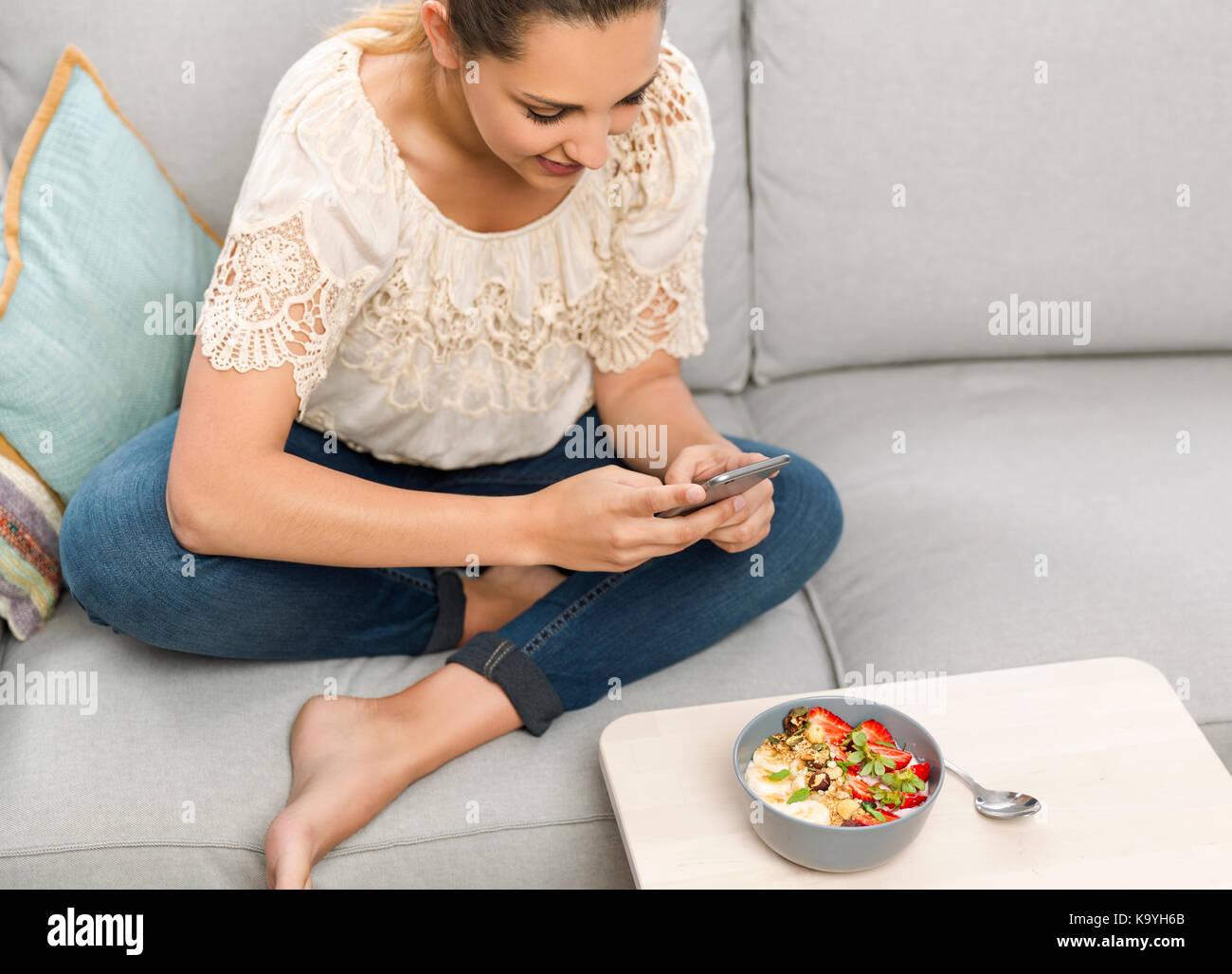 Woman sitting on the couch ready to eat and talking picture to her food ...