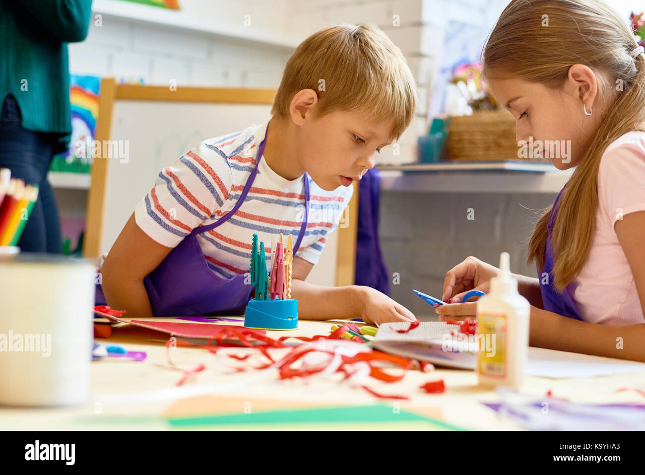 Portrait of two kids, boy and girl, making handmade gift cards in art ...
