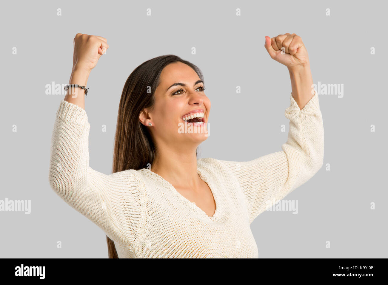 Studio shot of a happy young woman with arms raised Stock Photo - Alamy