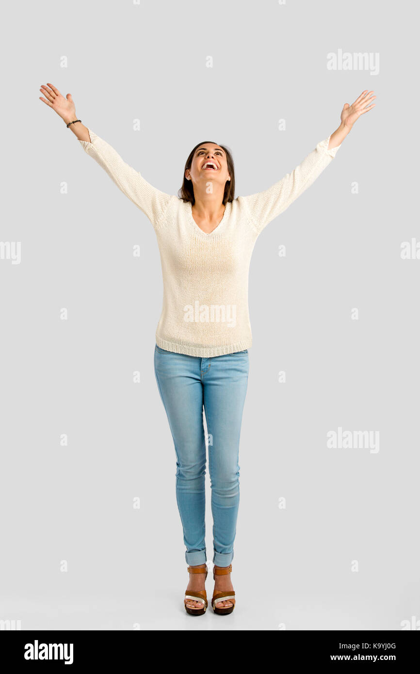 Studio shot of a happy young woman with arms raised Stock Photo - Alamy