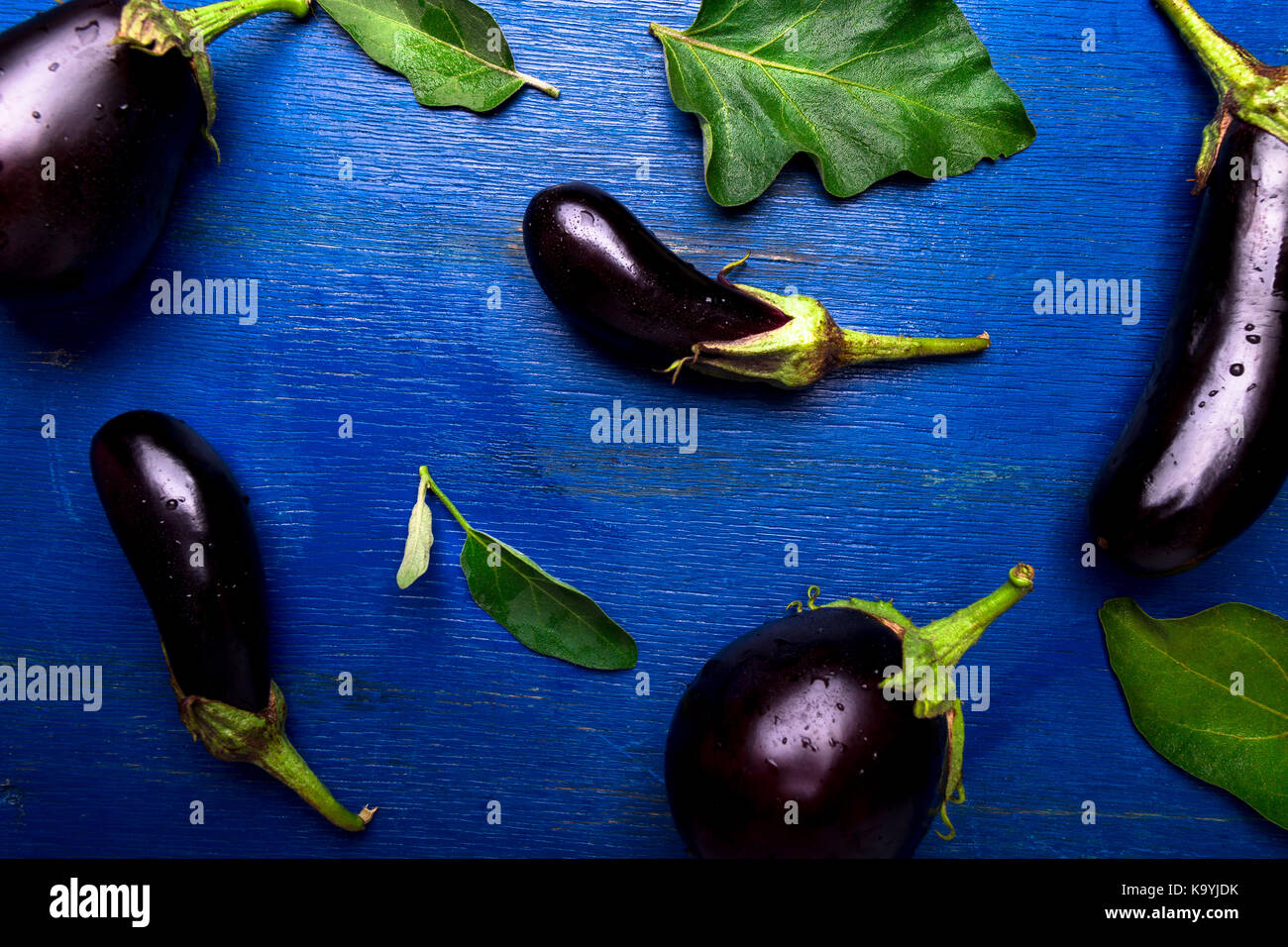 Fresh eggplant background with leaf. Top view. Blue rustic table Stock ...