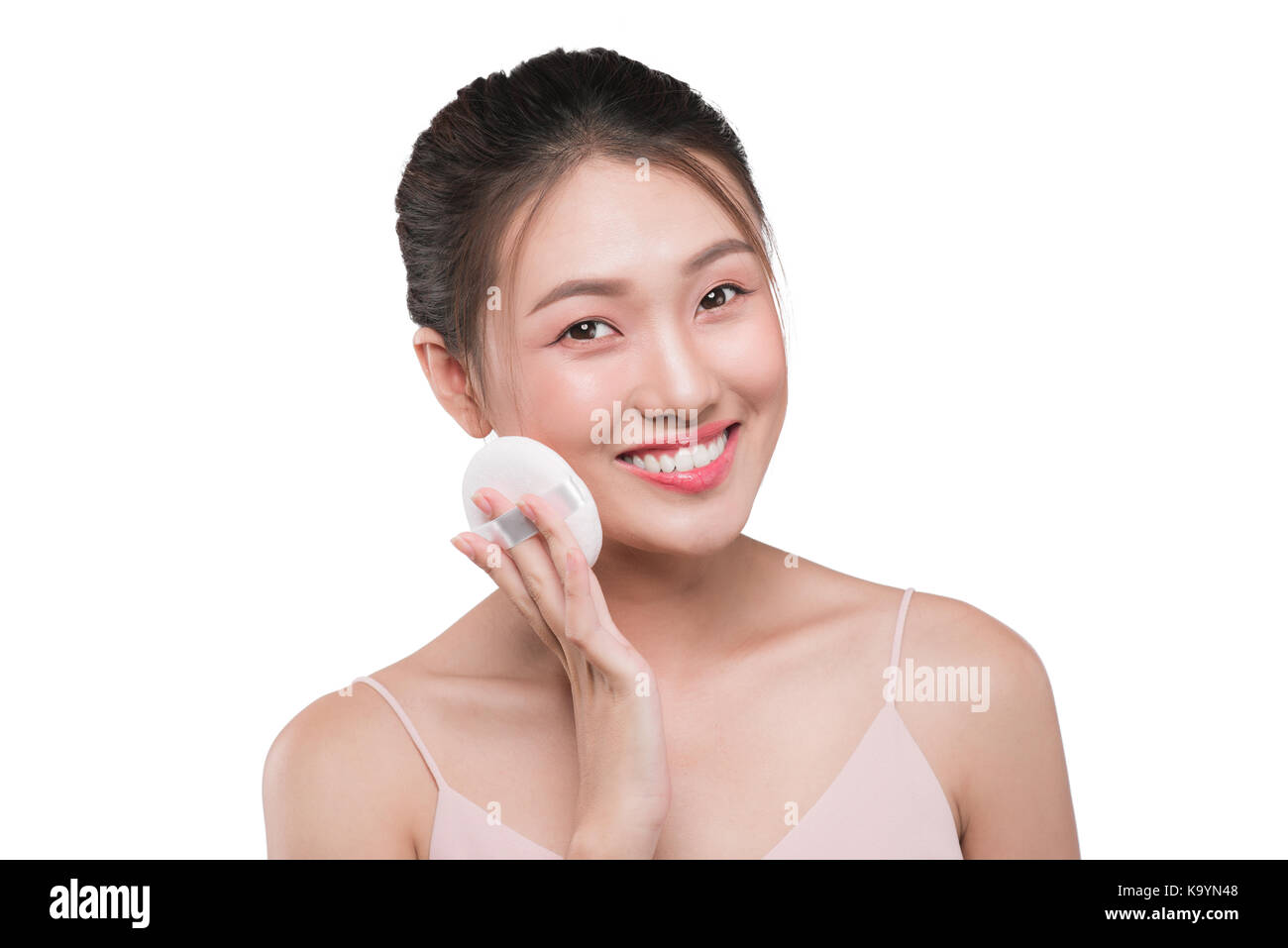 Portrait of beautiful young asian model applying some powder using ...