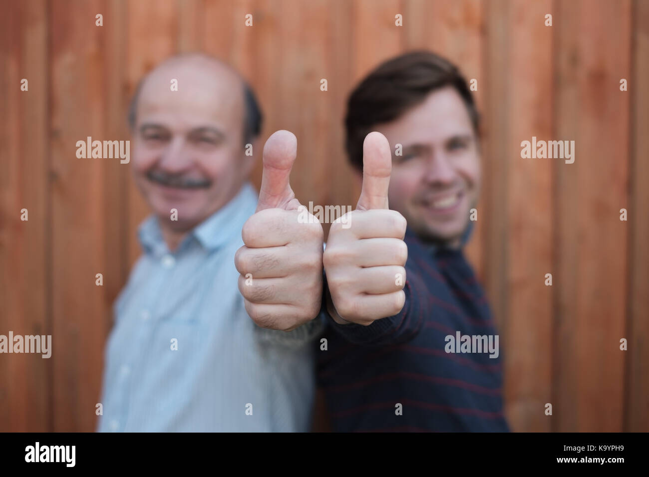 Two happy men giving thumbs up sign. Blurred photo Stock Photo - Alamy