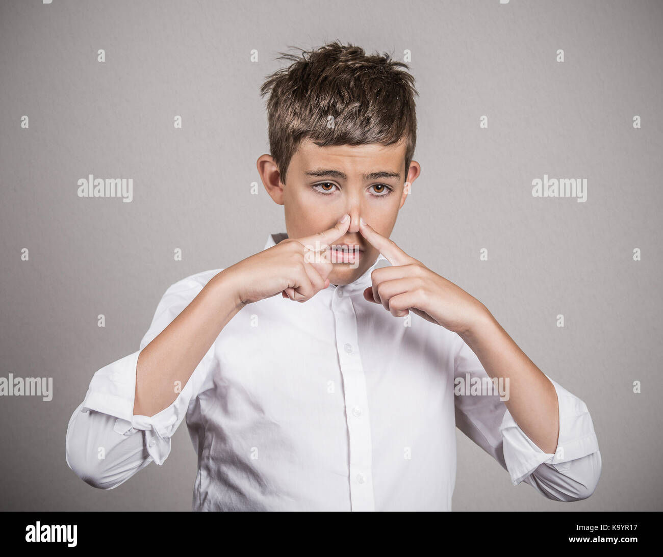 Closeup portrait young man with disgust on face, pinches his nose ...