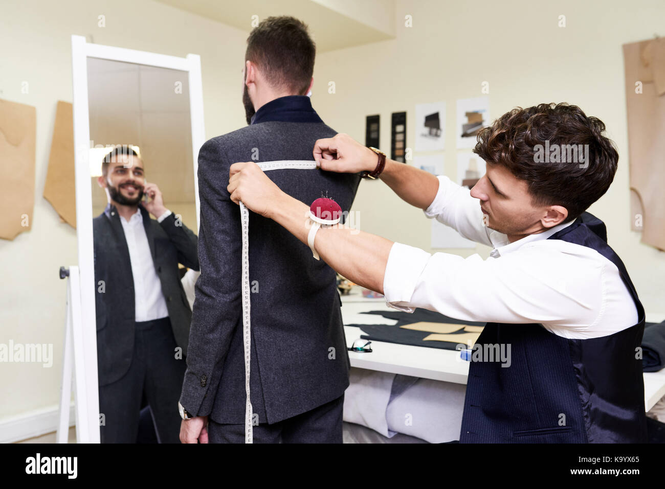 Working process at sewing atelier: concentrated tailor taking ...