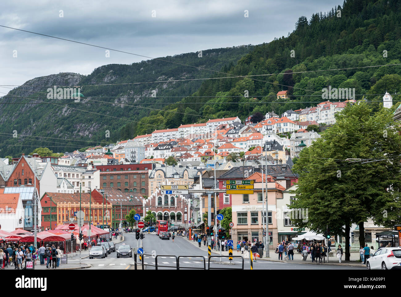 the famous city of bergen with houses build upon the hills and tourists ...
