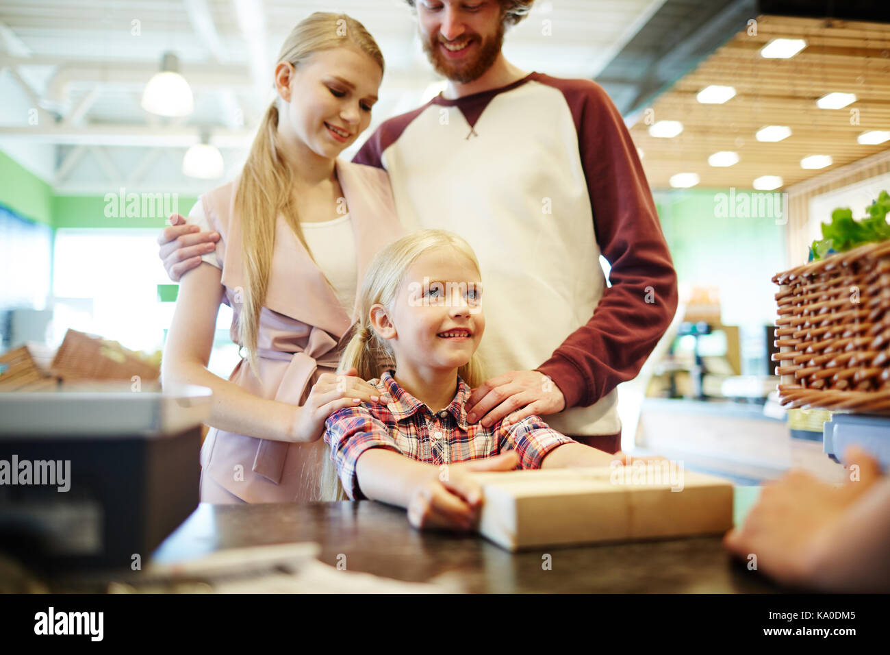 Family at cash register Stock Photo - Alamy