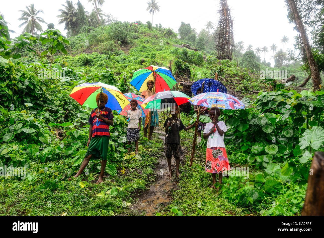 Native women with children with colourful umbrellas in the rain in the ...