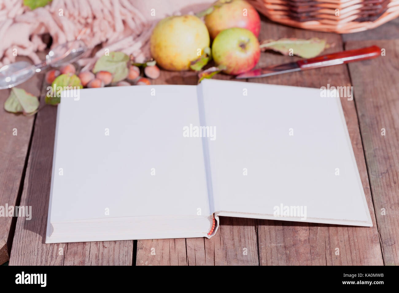 Open book on a wooden table with apples on an autumnal day Stock Photo ...