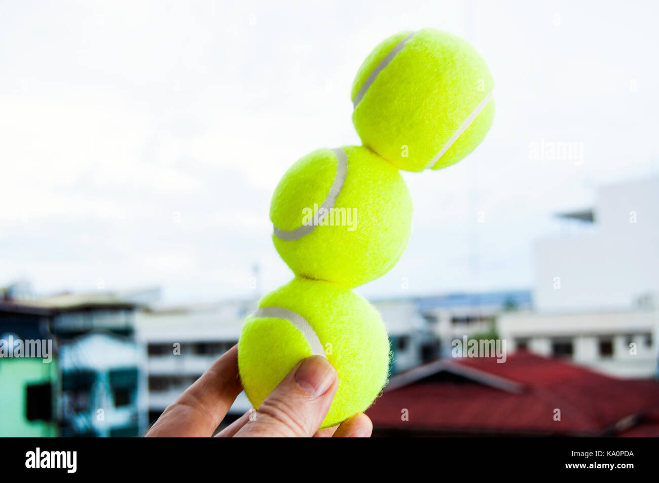Indoor shot with outdoor background of Model holding balancing tennis ...