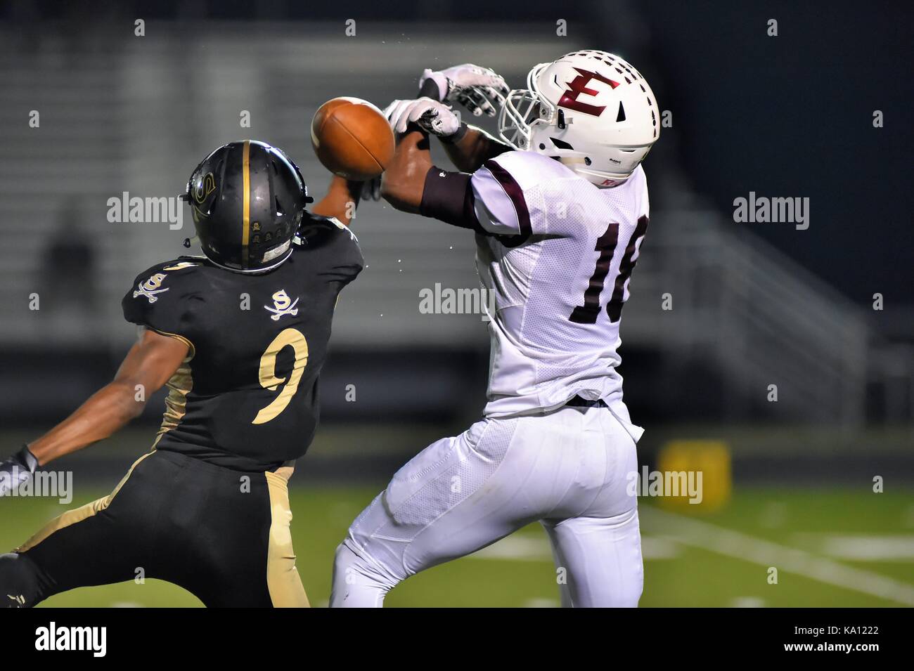 Defensive back, left, disrupting a pass reception attempt by wide out ...
