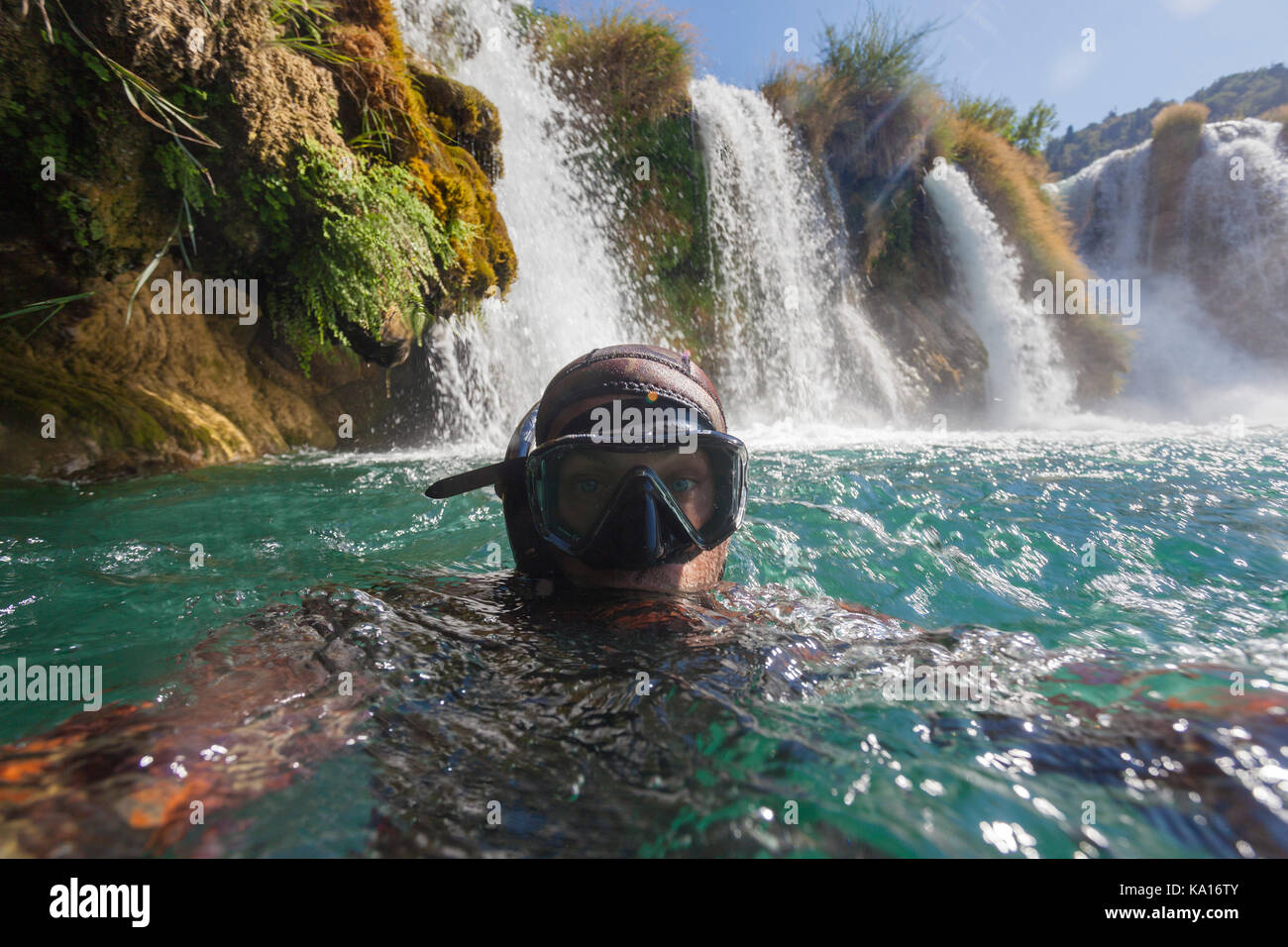 Diving under the waterfall of the Krka River Stock Photo - Alamy