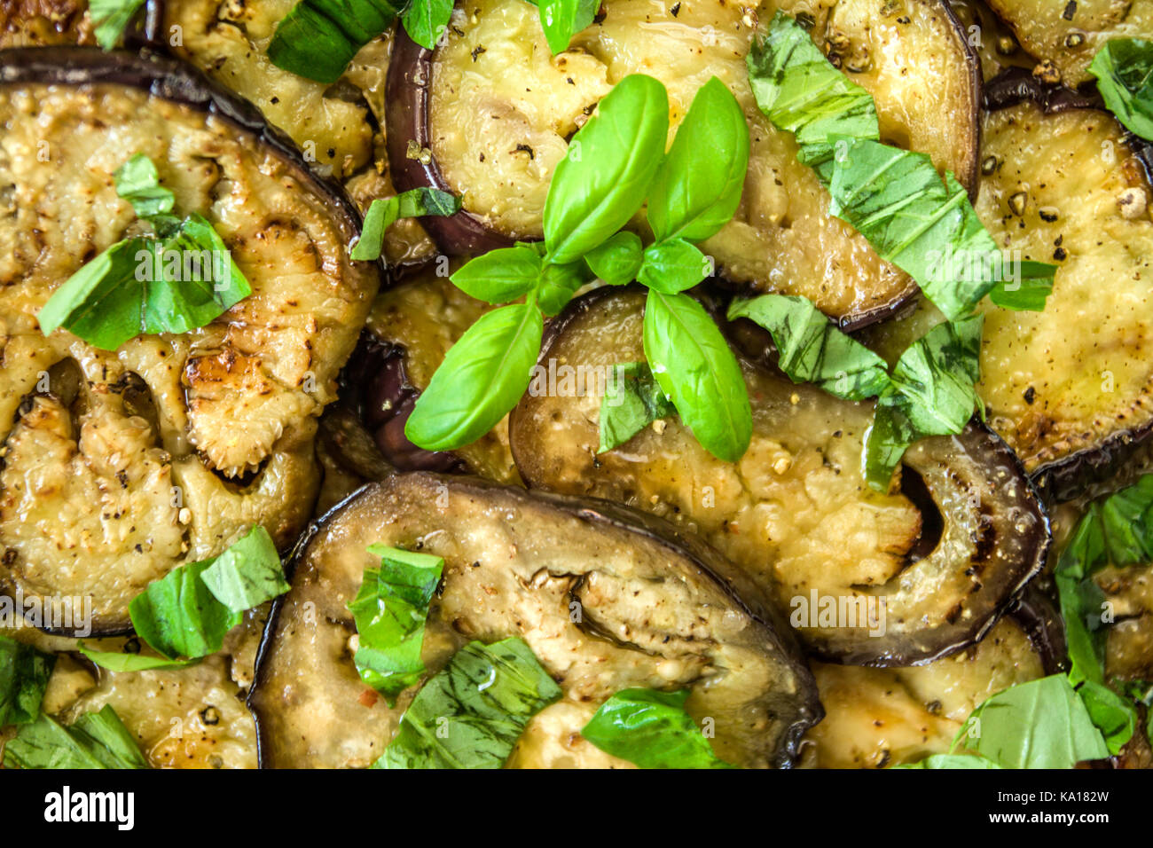 Fried and cooked aubergine with garlic basil in olive oil Stock Photo ...