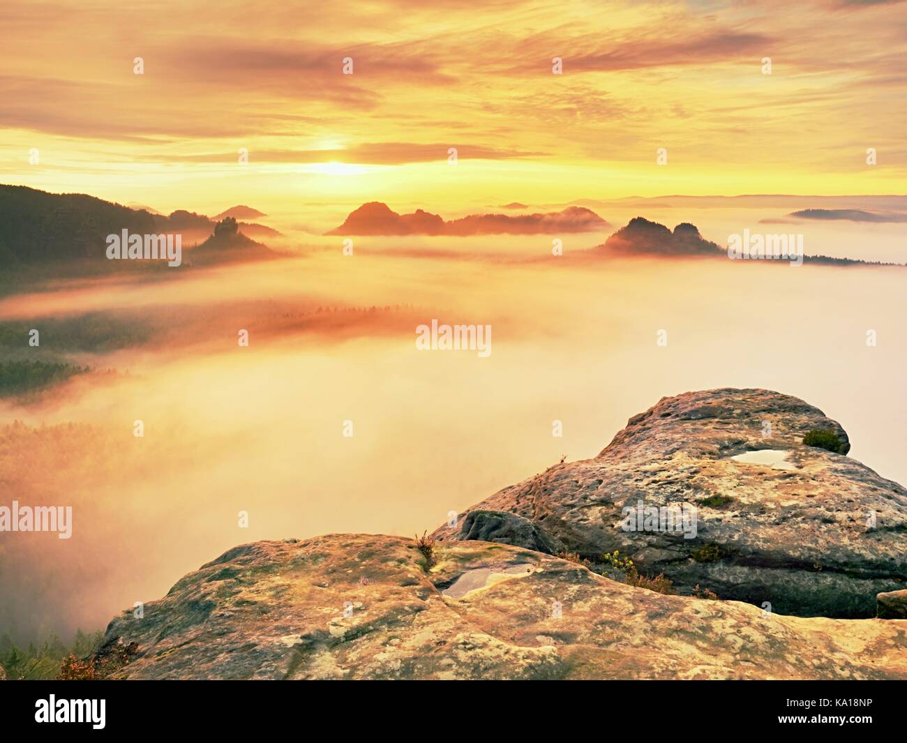 View over sharp sandstone edge into long valley full of first autumnal ...