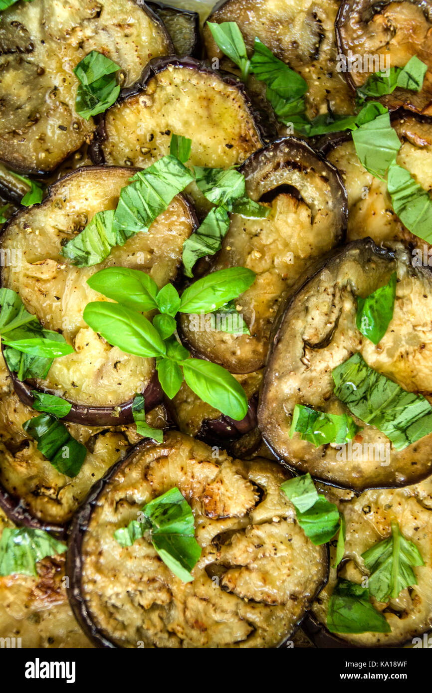 Fried and cooked aubergine with garlic basil in olive oil Stock Photo ...