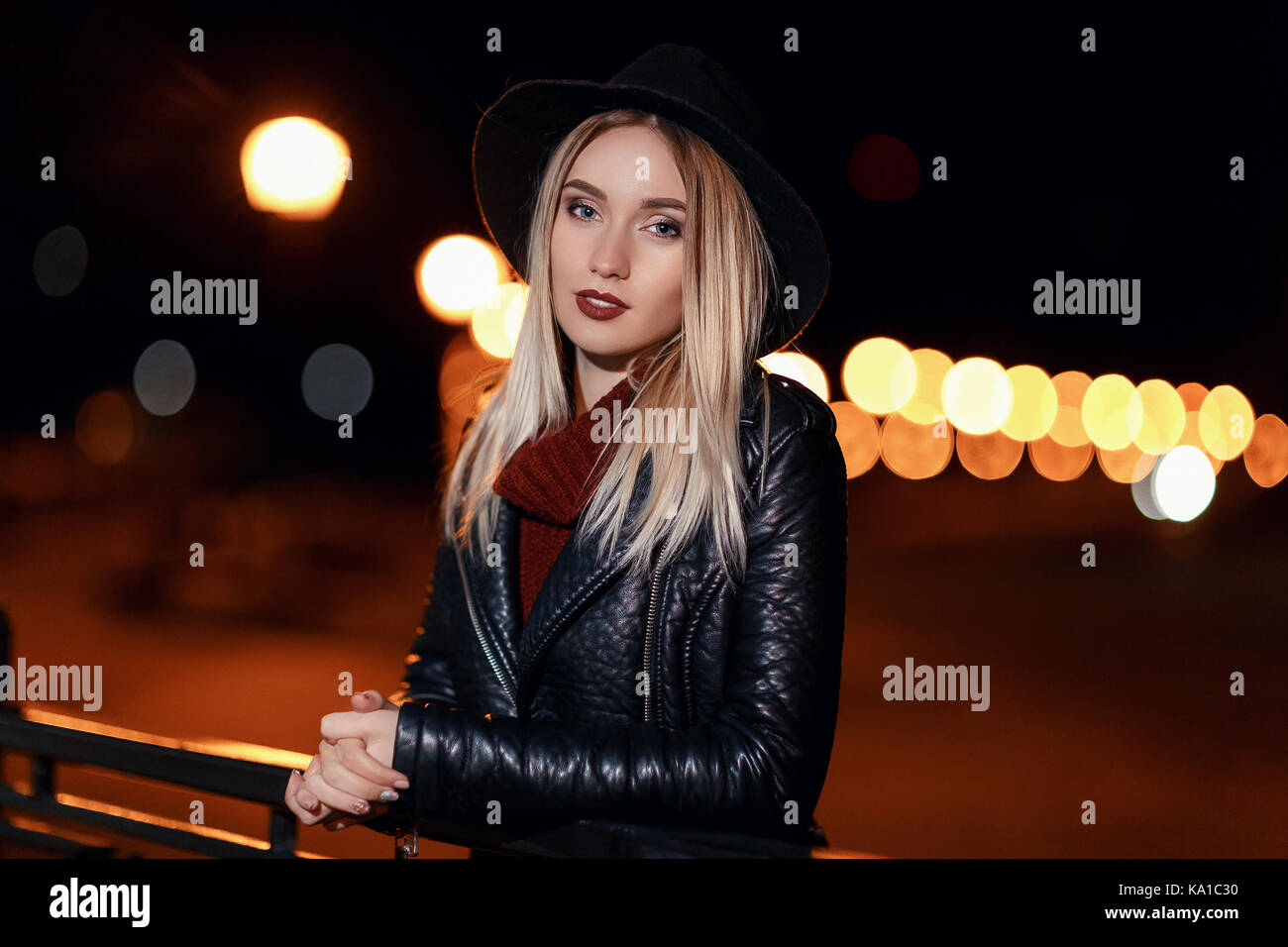 Portrait of a young beautiful girl. Model posing at night in a city ...