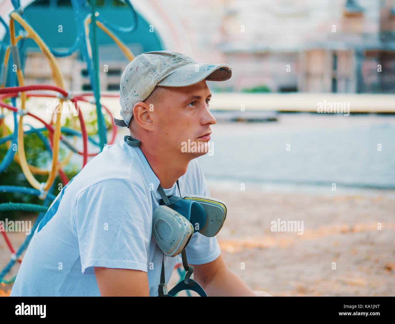 Young man portrait. Graffiti artist with protective mask sitting and ...