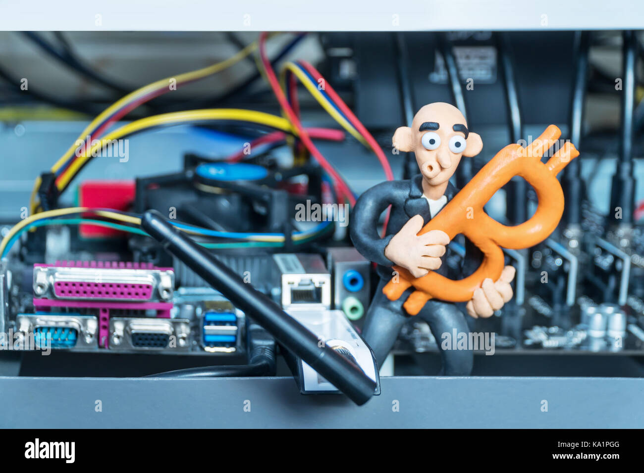 Bald plasticine man with a pickaxe in his hand sitting on the computer ...