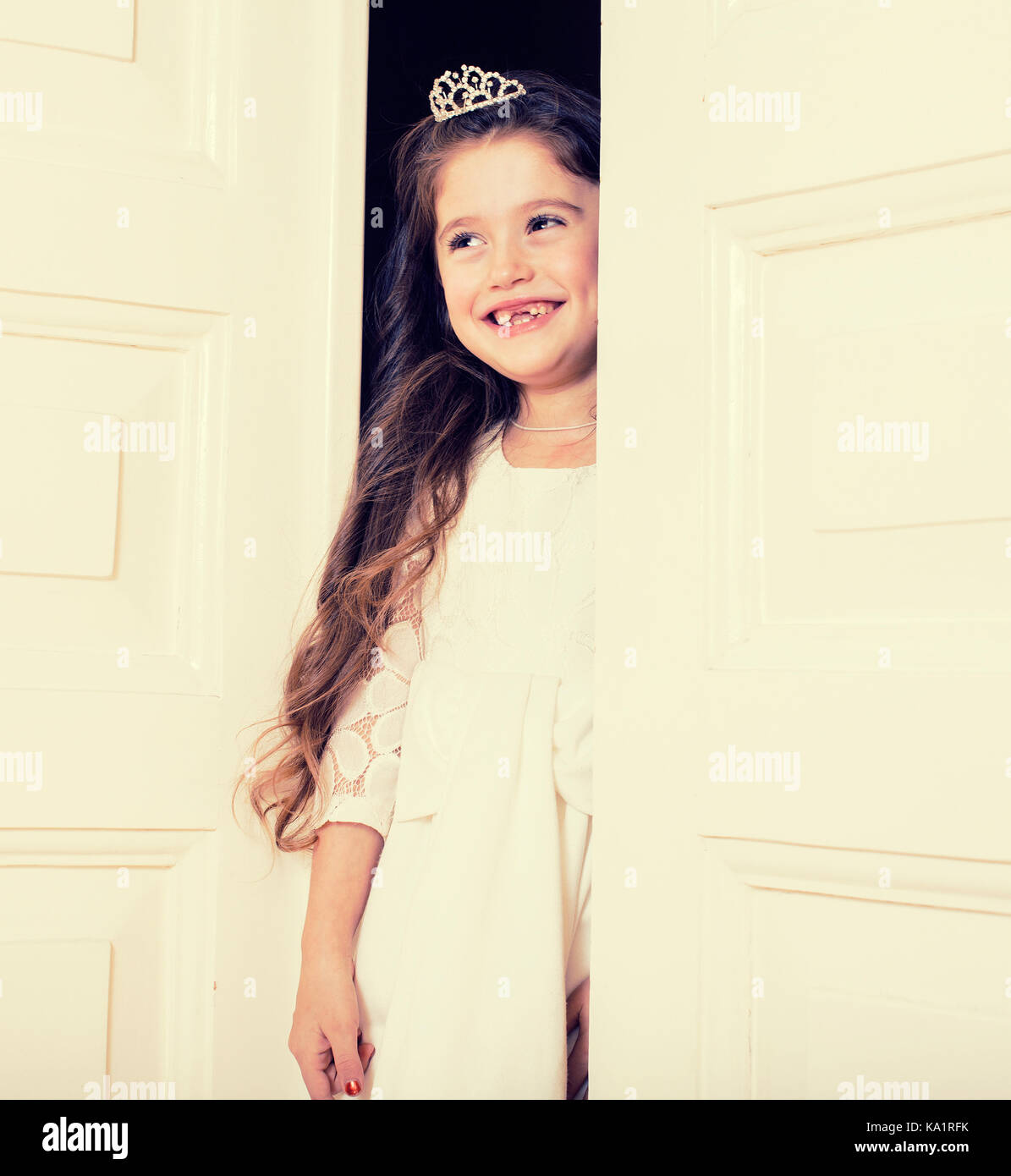 little cute girl at home, opening door well-dressed in white dre Stock ...