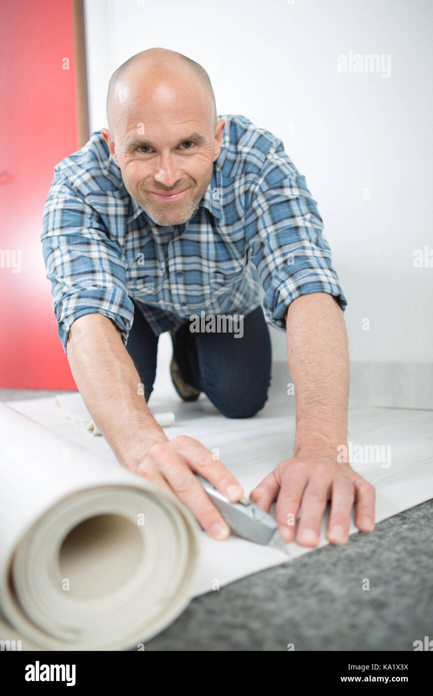 craftsman fitting carpet on floor Stock Photo - Alamy