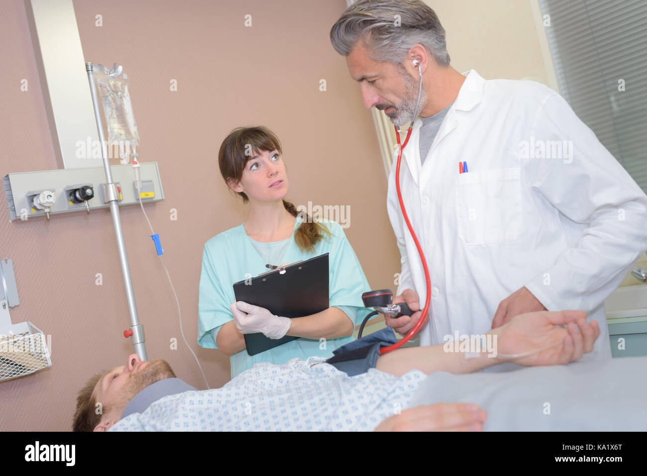 doctor and nurse checking patients pulse Stock Photo - Alamy