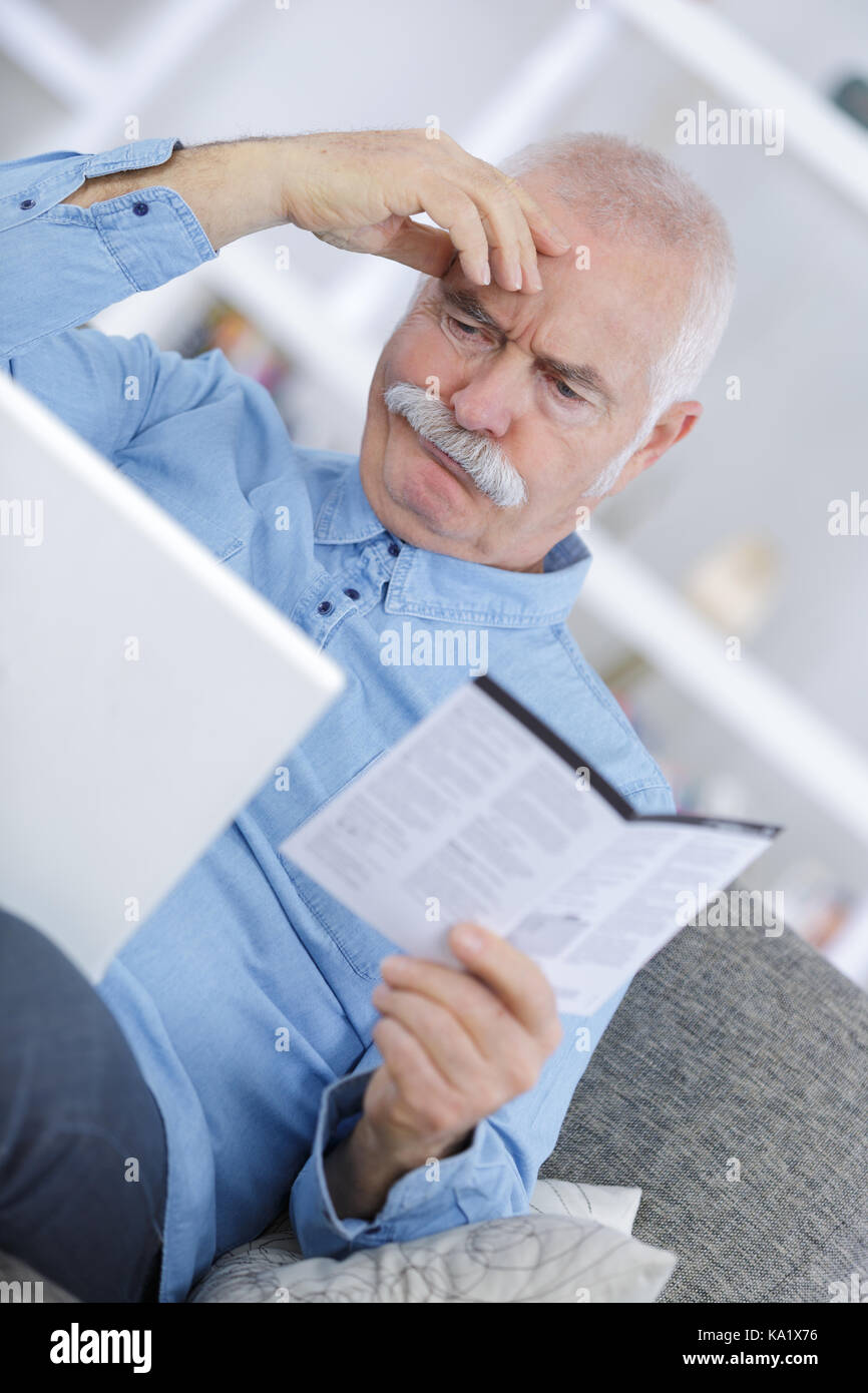 confused old man reading manual at home Stock Photo - Alamy