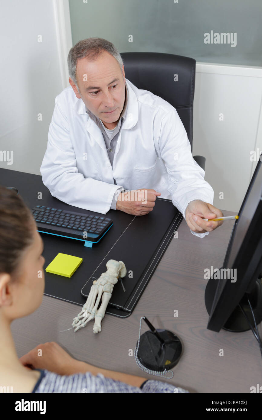 doctor with female patient pointing on computer Stock Photo - Alamy