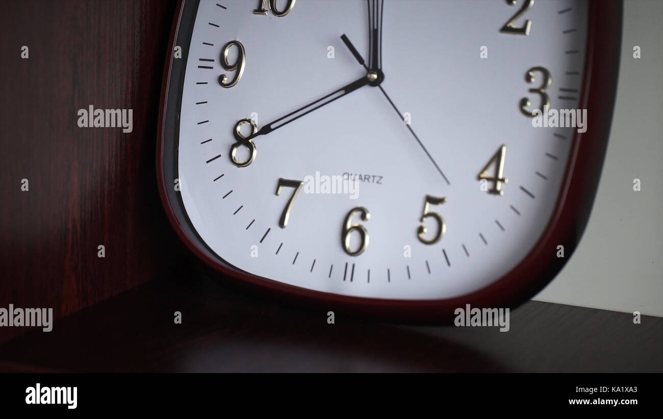 White wall clock. Oval wall clock shows 11:40. Time Stock Photo - Alamy