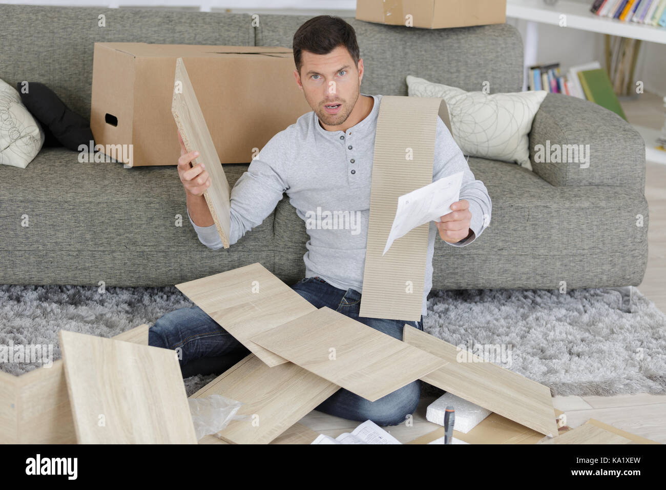 man having a problem with furniture assembling Stock Photo - Alamy