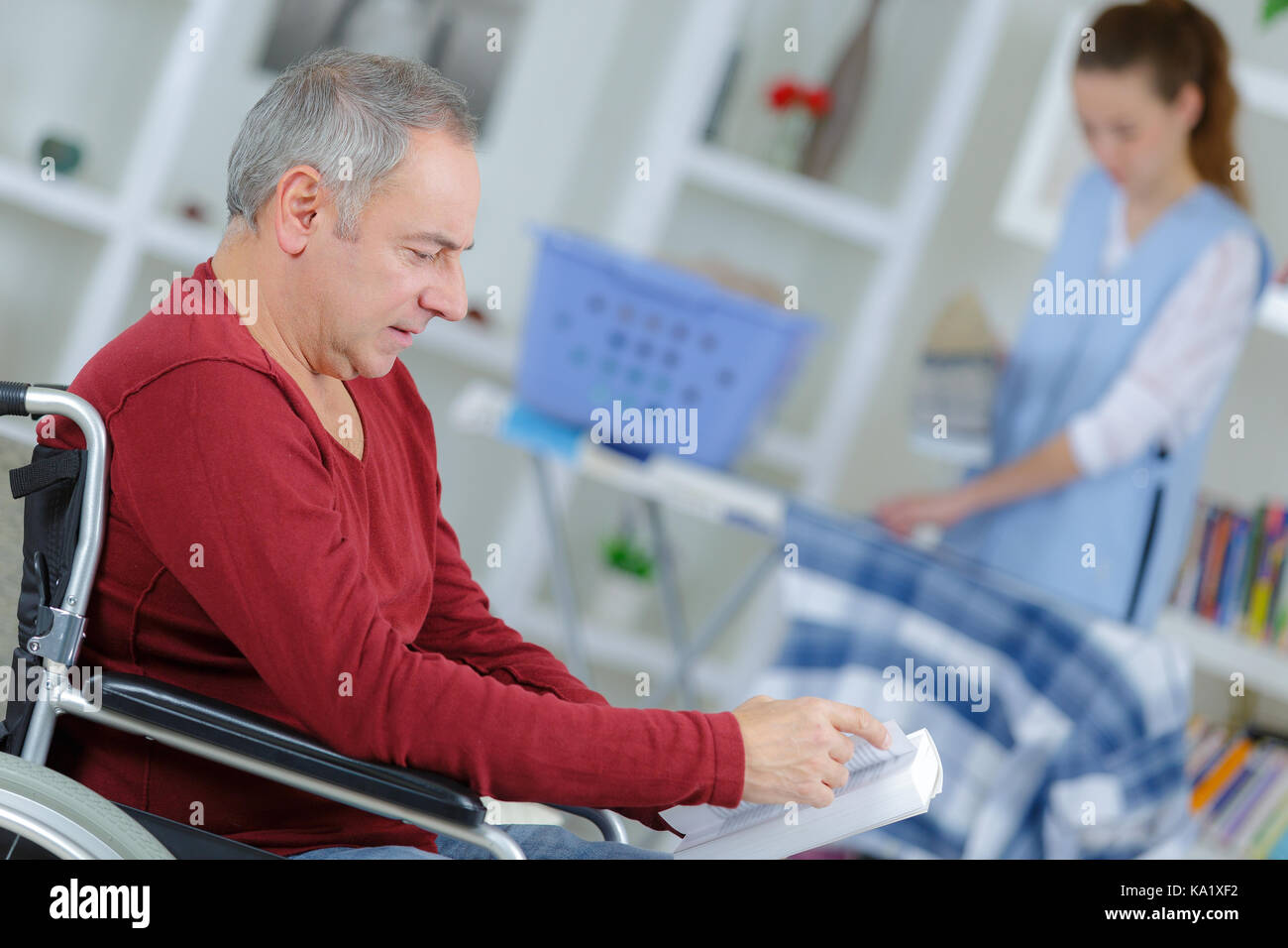 assistant helping man in wheelchair Stock Photo - Alamy
