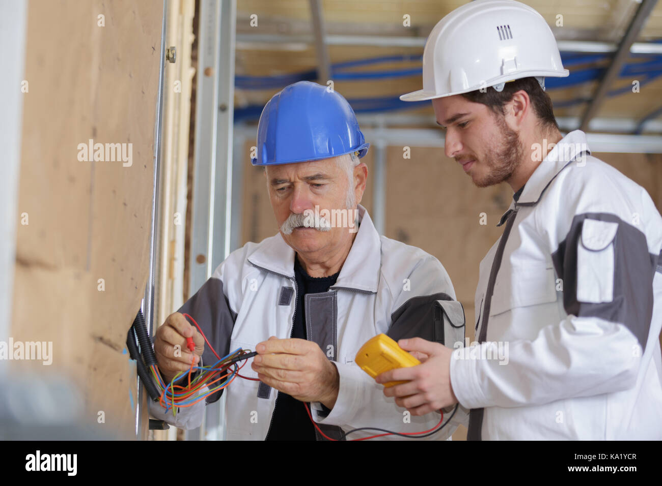young electrician and senior supervisor at work Stock Photo - Alamy