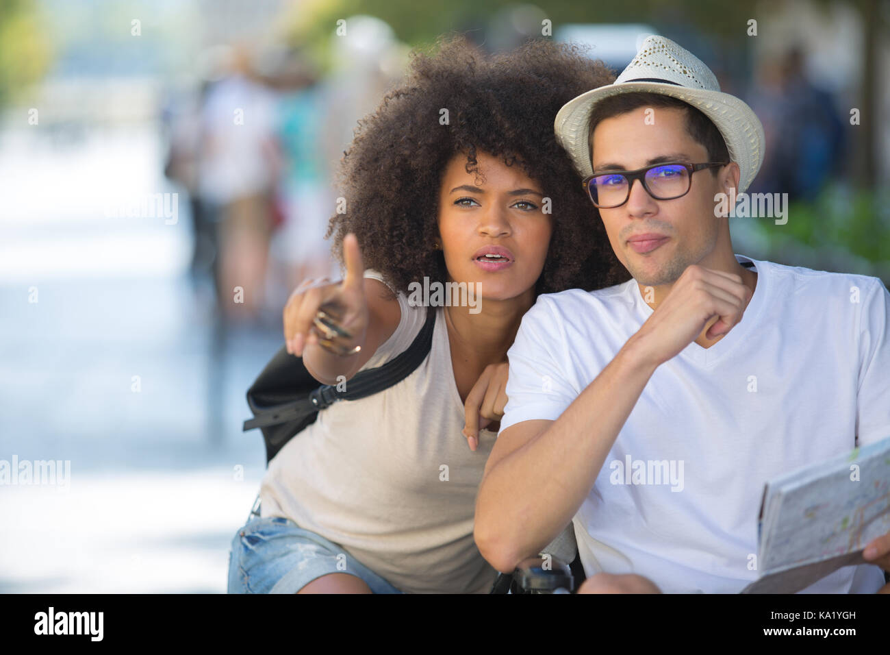 young couple using city map and pointing Stock Photo - Alamy
